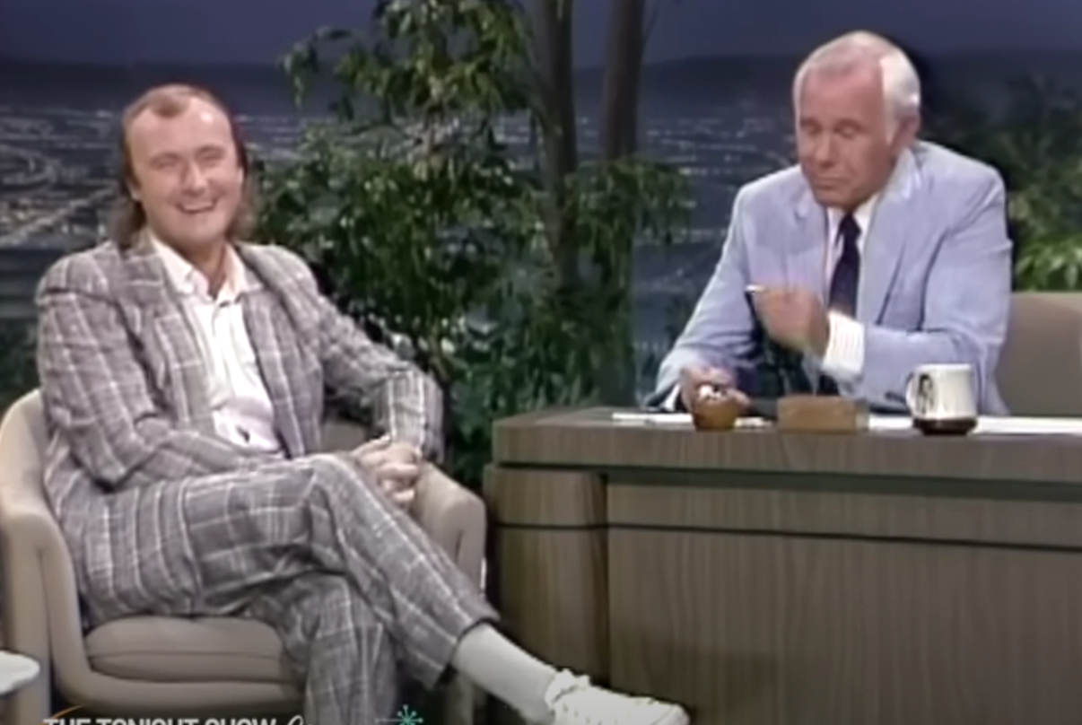 Phil Collins Sits Down With Johnny Carson and Performs 'Against All ...
